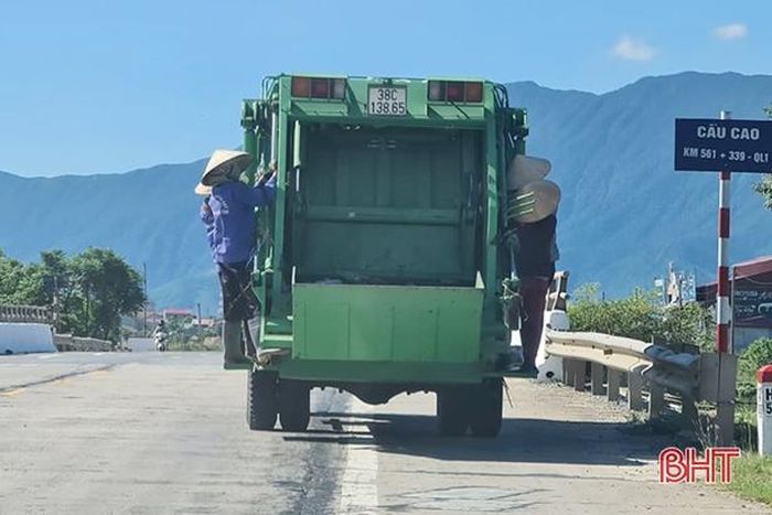 4 nữ công nhân đu bám sau xe thu gom rác thải khi đang lưu thông trên ...